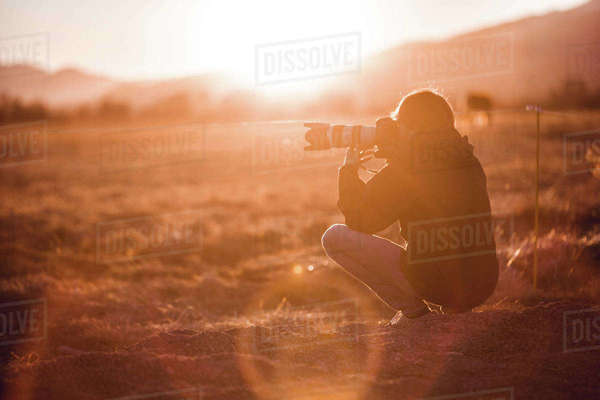 Back view of male taking photo of beautiful landscape between hills in ...