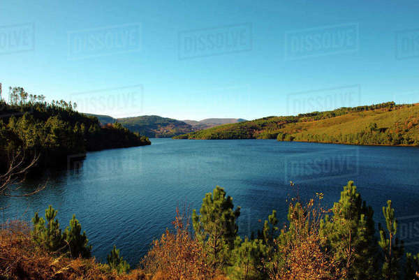 Calm river flowing between green hills - Stock Photo - Dissolve