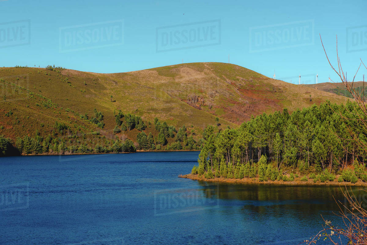 Calm river flowing between green hills - Stock Photo - Dissolve