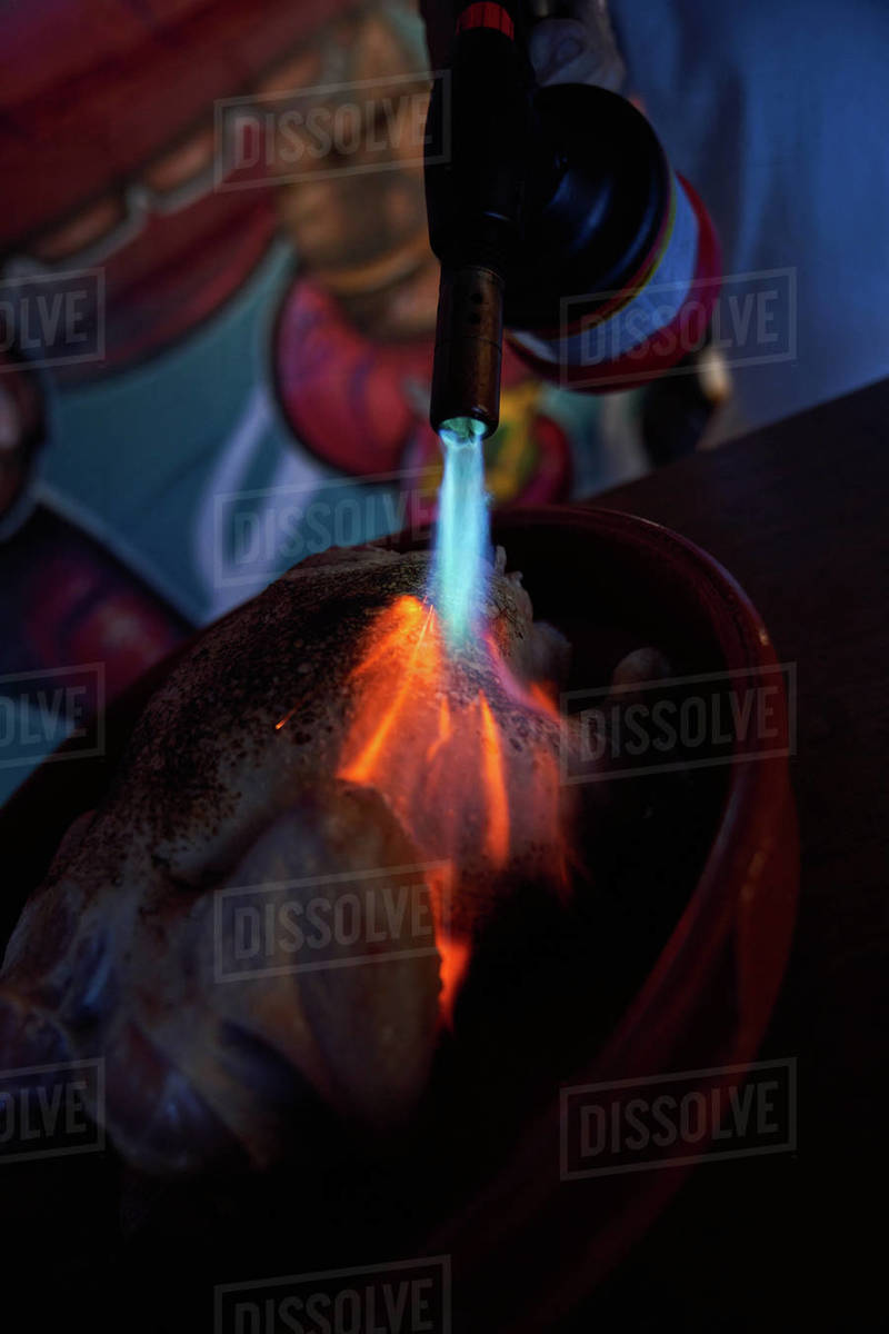 Whole fresh chicken during processing with flamethrower with bright gas ...