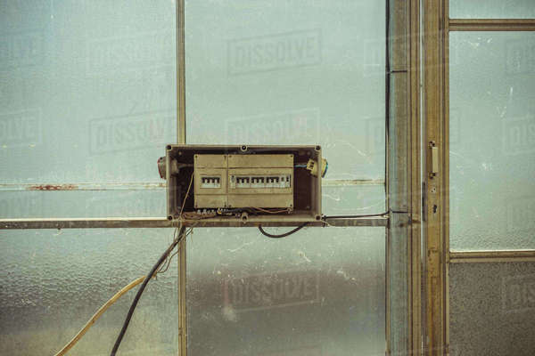 Broken control panel of circuit breaker placed on glass wall of ...