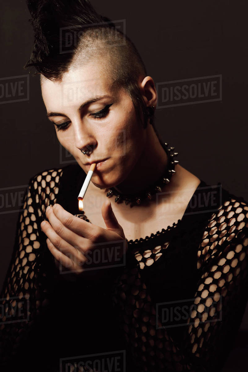 Adult female with mohawk and piercing smoking cigarette - Royalty-free ...