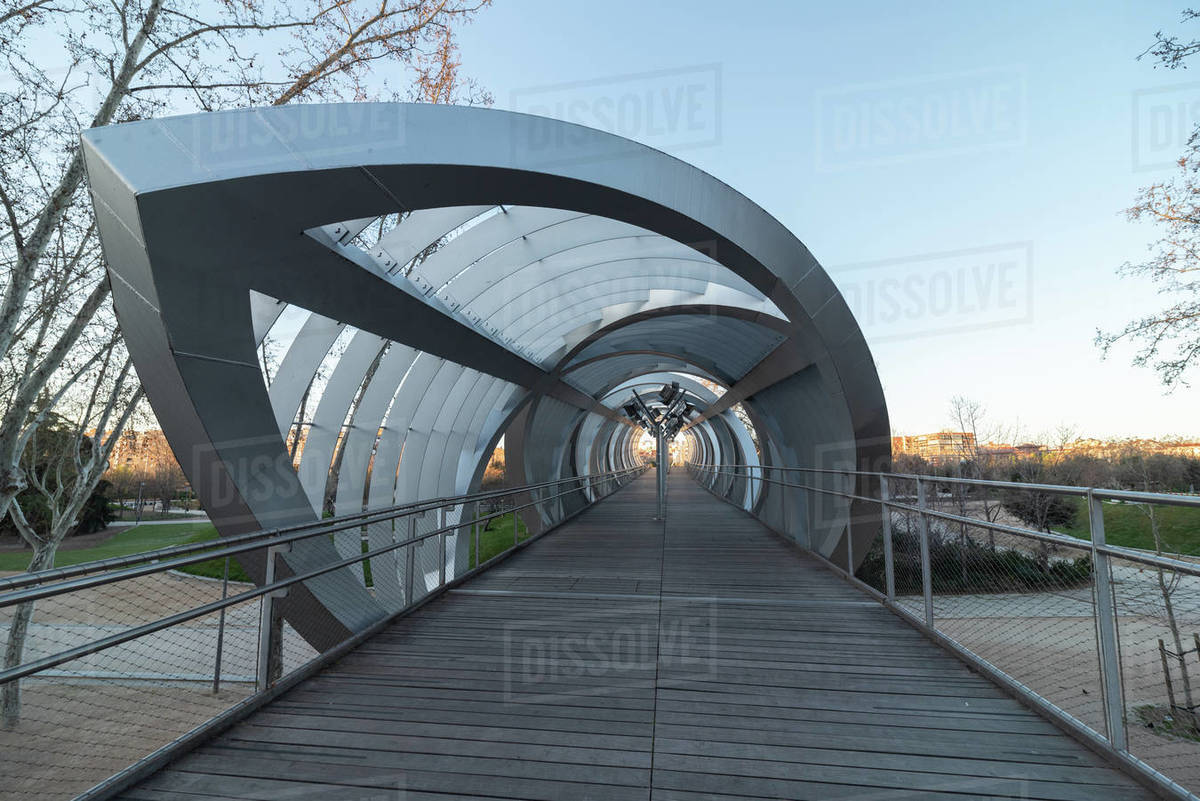 Perspective view of paved wooden bike path going to futuristic gallery ...