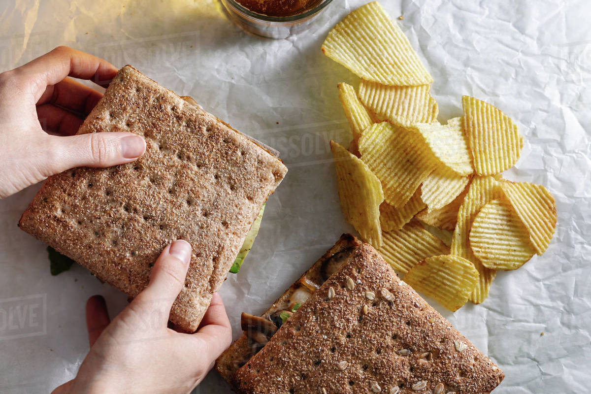 Top view of unrecognizable person with palatable sandwich with ...
