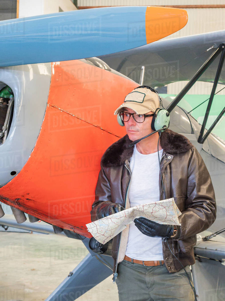 Pilot with map beside small plane - Royalty-free Stock Photo | Dissolve