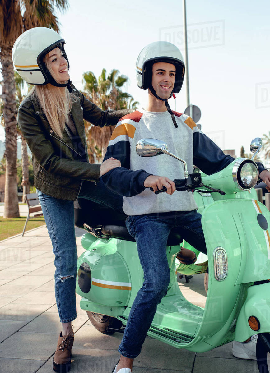 Young couple getting on motorcycle together on road street - Royalty ...