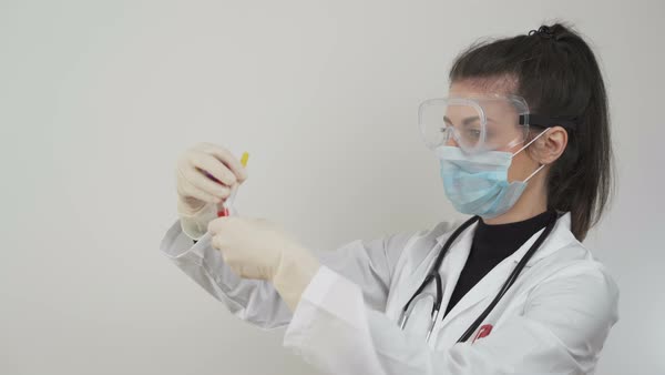 Doctor with face mask and protective glasses working with SARS-CoV-2 in ...