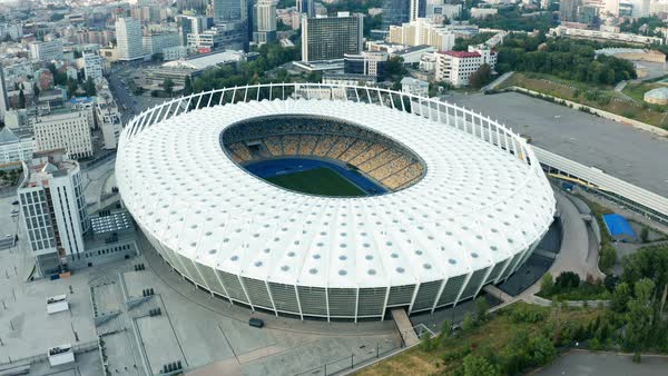 Drone aerial footage of huge football stadium with a grass field seen ...