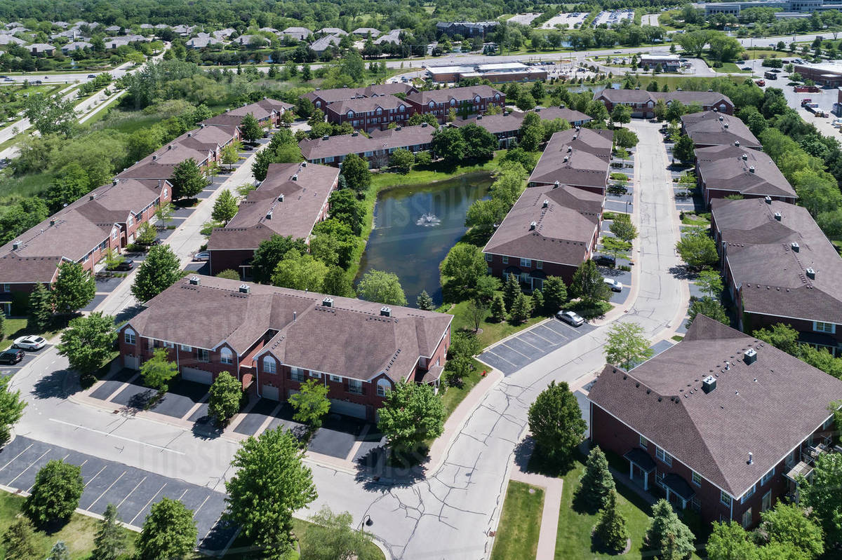 Aerial view of a townhouse complex with a small pond in a Chicago ...