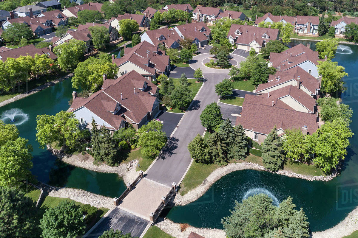 Aerial view of a luxury townhouse complex with a creek bordering the ...