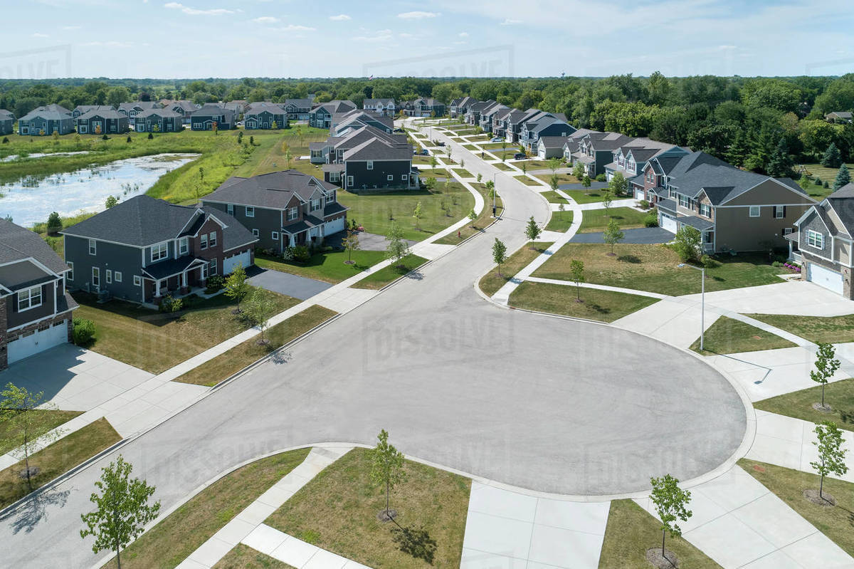 Aerial view of a housing community in a neighborhood with pond in a ...