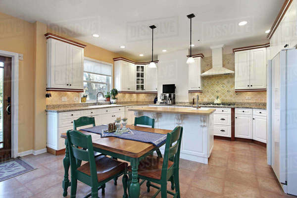 Kitchen in suburban home with eating area and green chairs. - Royalty ...