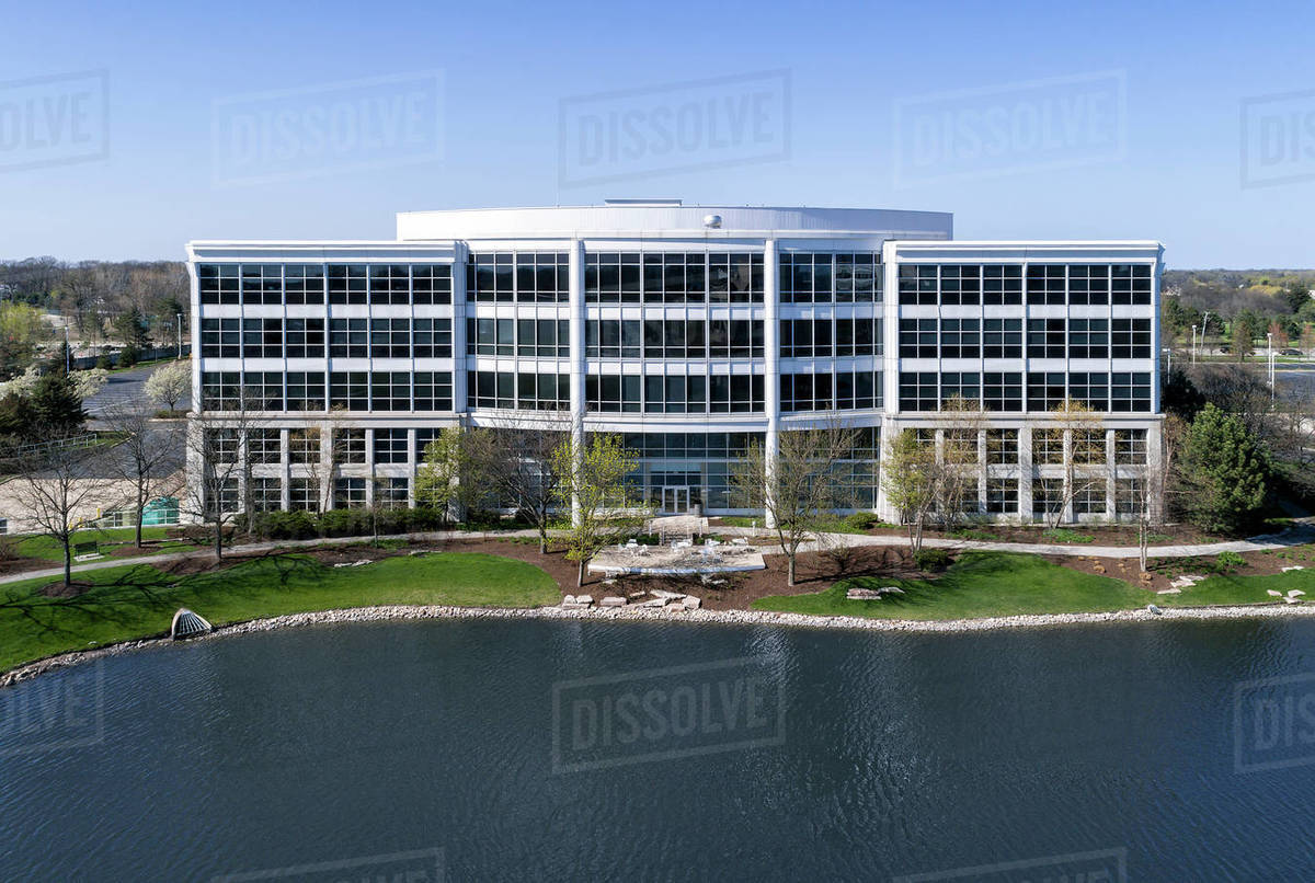 Office building headquarters in office park during spring with pond ...