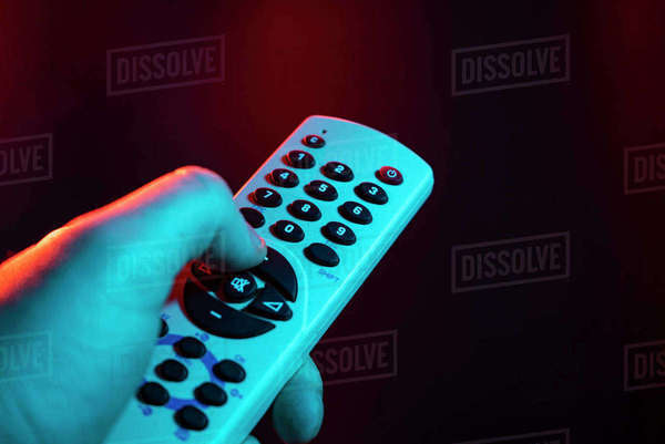 Hold remote control in hand and zap. Male hand is holding TV remote ...