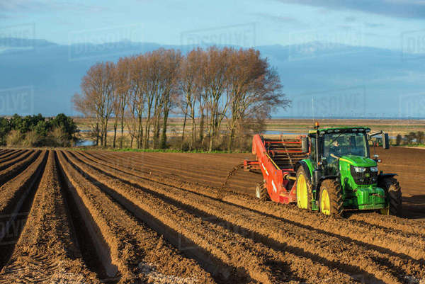 Rural landscape, tractors ploughing and sowing fields in early Spring ...