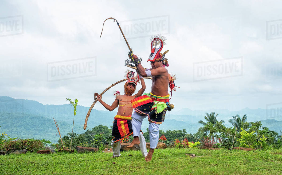 Caci men perform a traditional whip dance with bamboo shields and ...