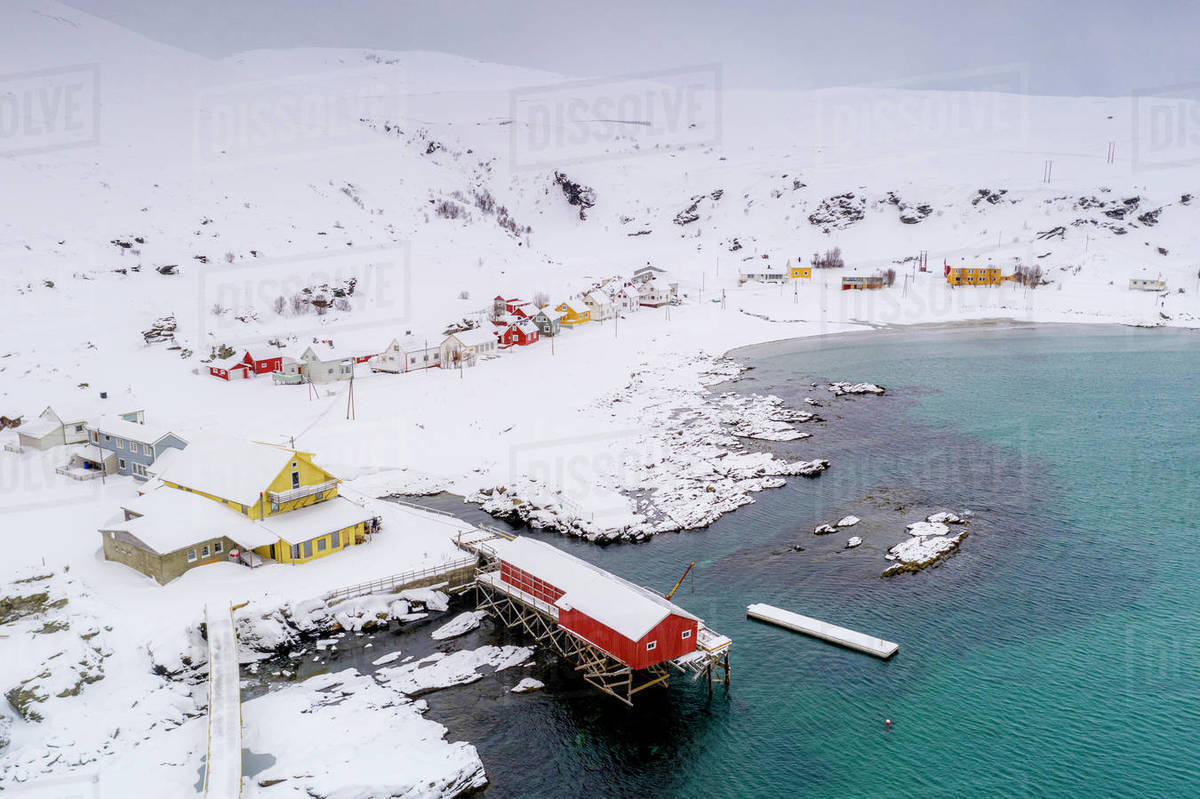 Fishing village of Sorvaer framed by the cold sea during a snowy winter ...