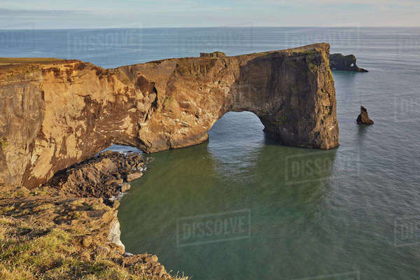 A rock arch on the southern shore of spectacular Dyrholaey Island, near ...