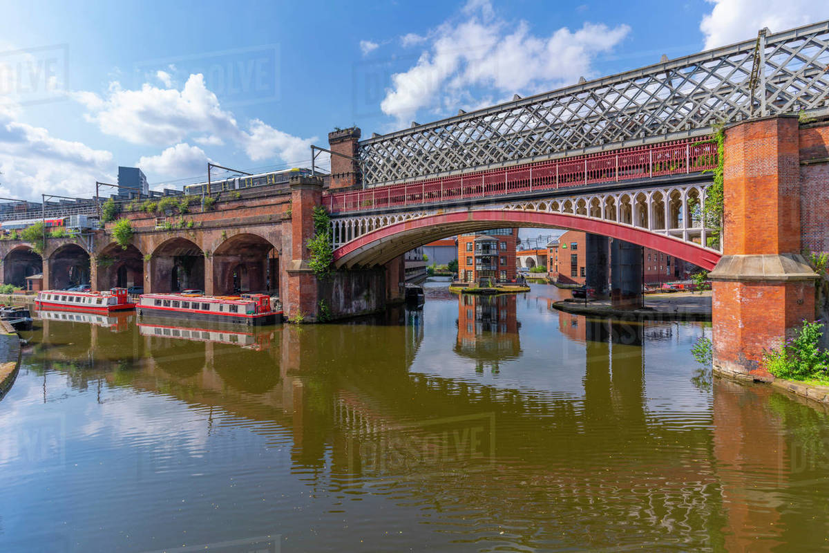 View of tram and train bridges reflecting in Castlefield Canal ...