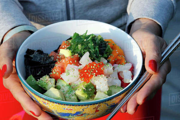 Asian cuisine, fish poke bowl with seaweed, avocado, cucumber, radish ...