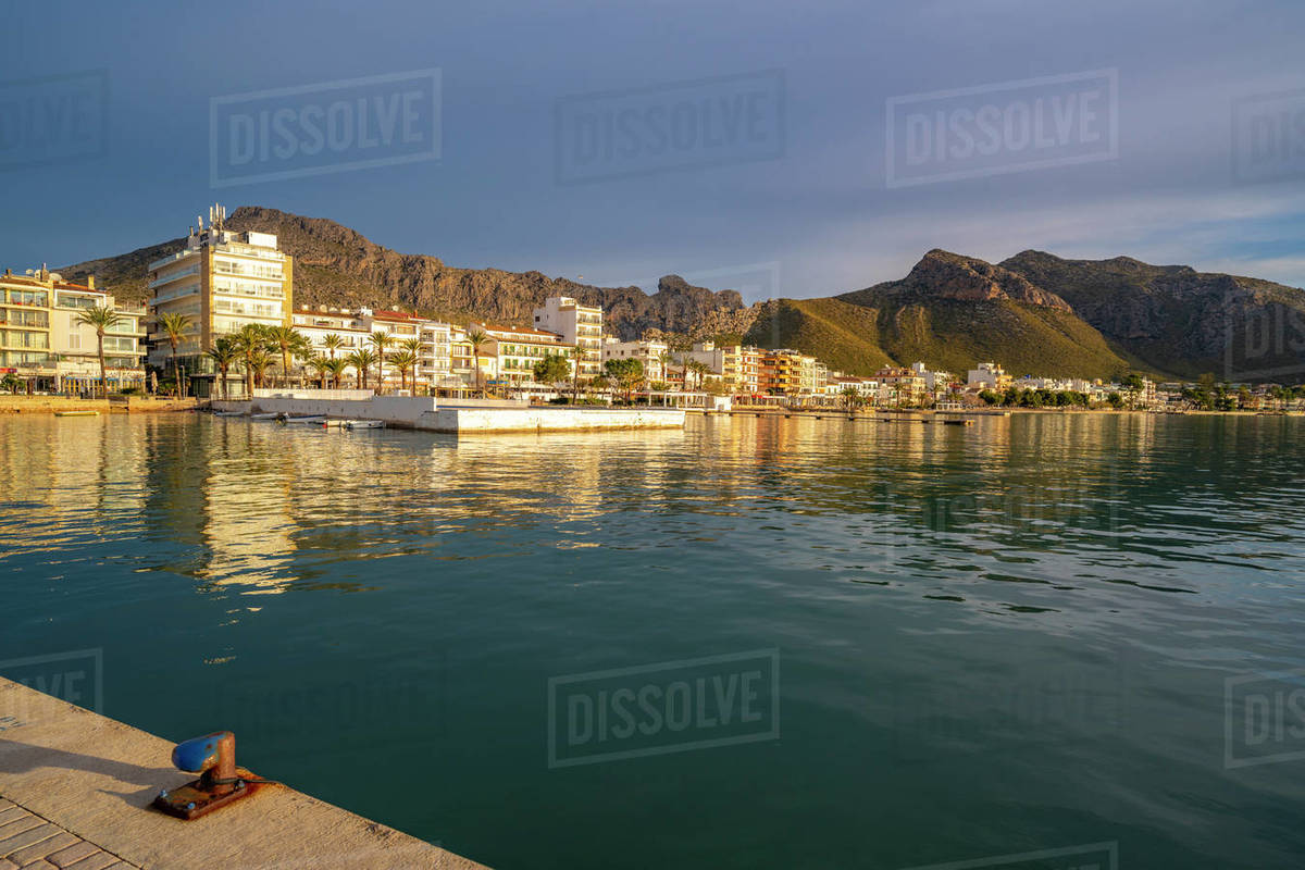 View of sunrise reflecting on hotels and bars in Port de Pollenca, Port ...