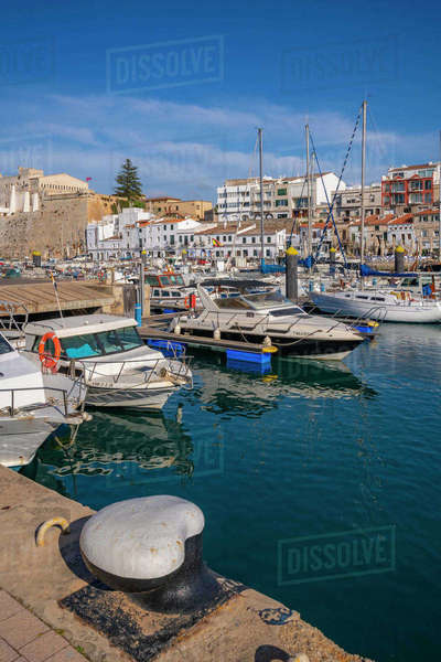 View of boats in marina overlooked by whitewashed houses, Ciutadella ...