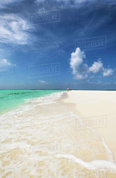 A man walking on a sandbank in the Indian Ocean, Baa Atoll, Maldives ...