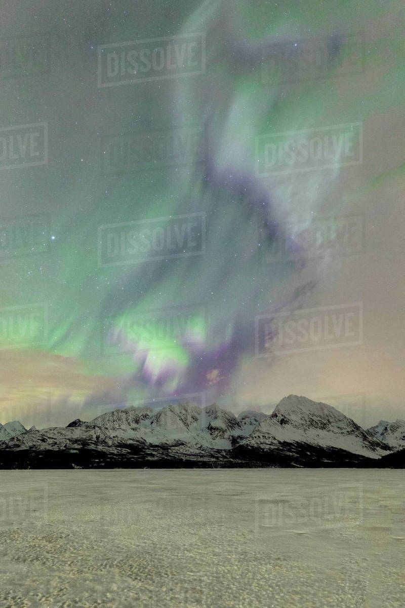 The icy lake of Jaegervatnet framed by the Northern Lights (aurora ...