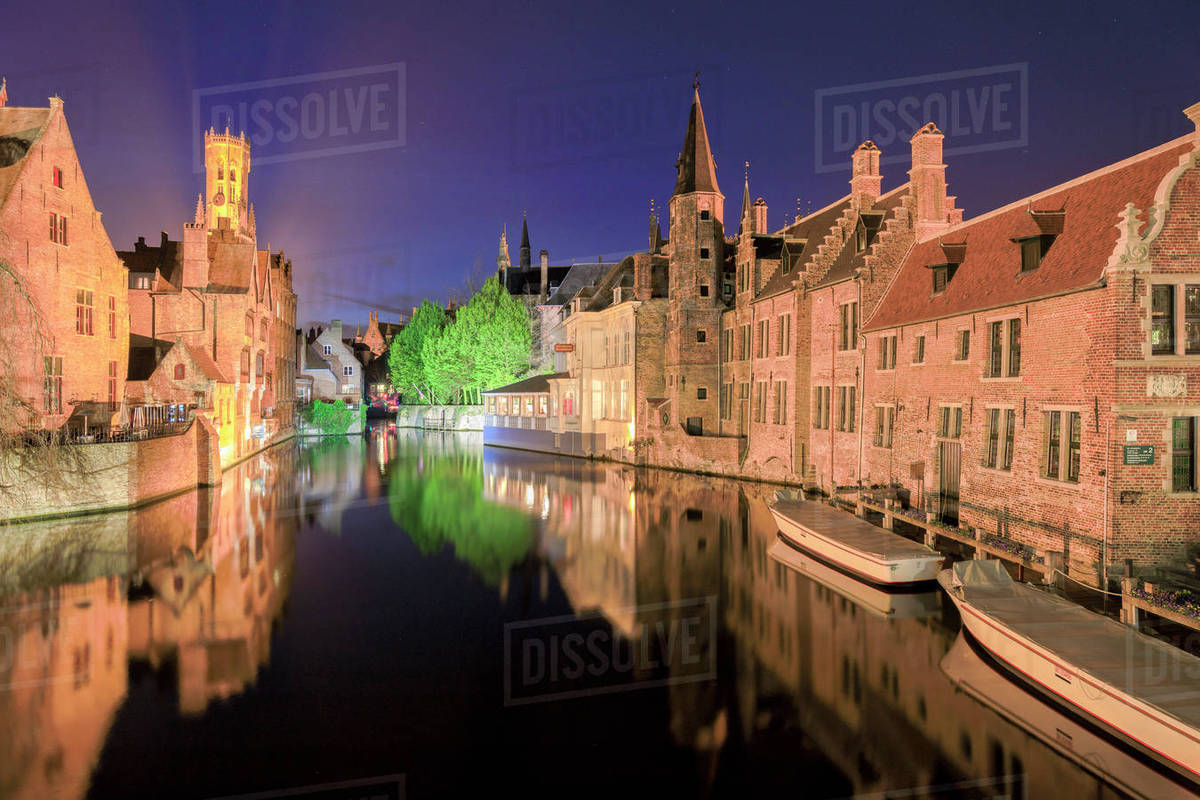 The medieval Belfry and historic buildings are reflected in ...
