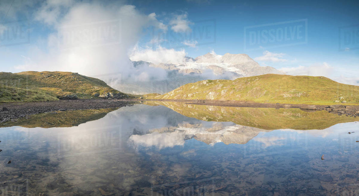 Panoramic of mountain peaks reflected in lake, Bernina Pass, Poschiavo ...