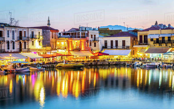 Old Venetian harbour, taverns on seaside at dusk, Rethymno (Rethymnon ...