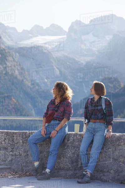 Mountain trip. two happy girls on the background of a mountain lake and ...