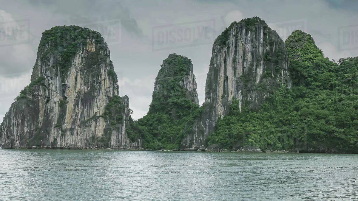 A view from a tour boat of three peaks and limestone cliffs at halong ...