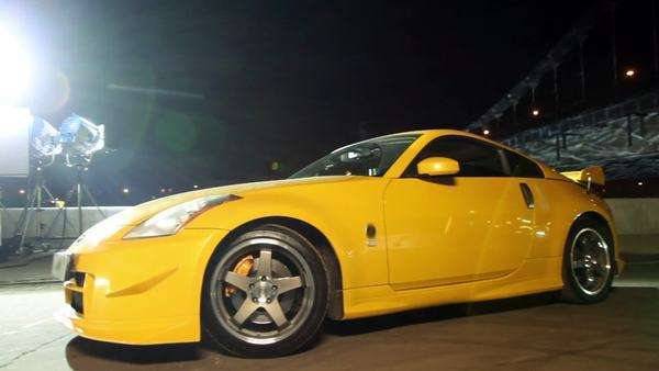 Light equipment illuminates yellow sport car stand at background of ...