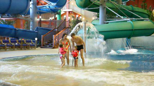 Charming woman in orange bathing suit, a man and two children in life ...