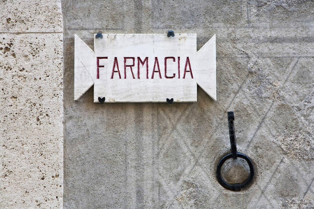 Italy, Tuscany, Pienza. Pharmacy sign on wall. - Stock Photo - Dissolve