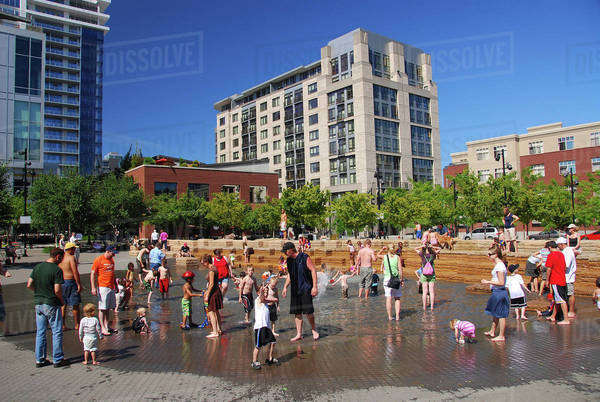 USA, Oregon, Portland. Families gather at Jamison Square Fountain ...