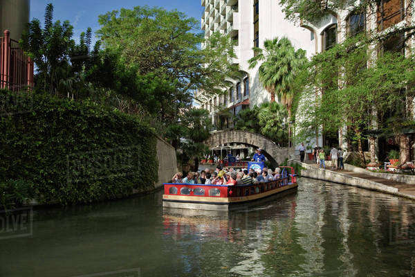 Tourists on boat cruising the San Antonio River along the famous River ...