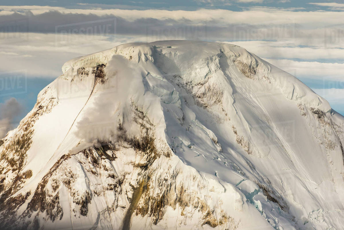 Aerial view Iliamna volcano rising up in Aleutian mountain range of ...