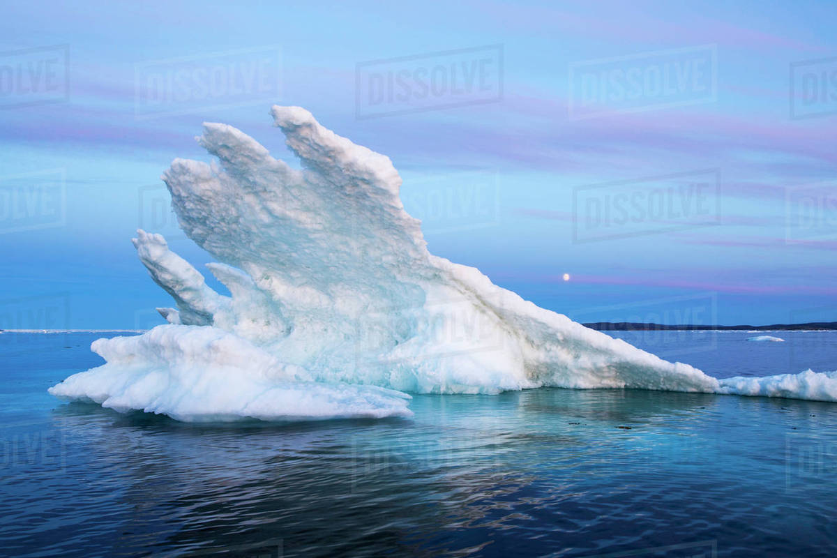 Canada, Nunavut Territory, Moon rises behind melting iceberg in Frozen ...