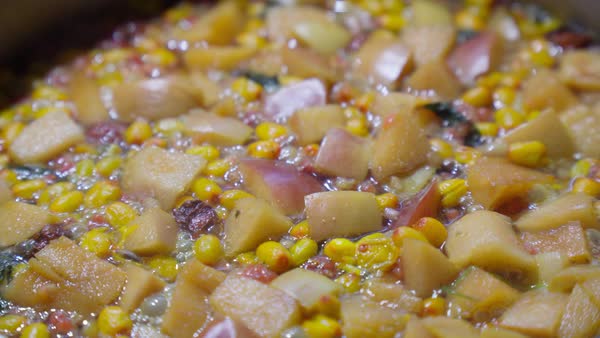 Boiling water from fruit in a metal man on a stone with bubbles and ...