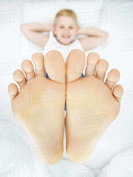 The boy lay on the bed and show feet. view from above - Stock Photo ...