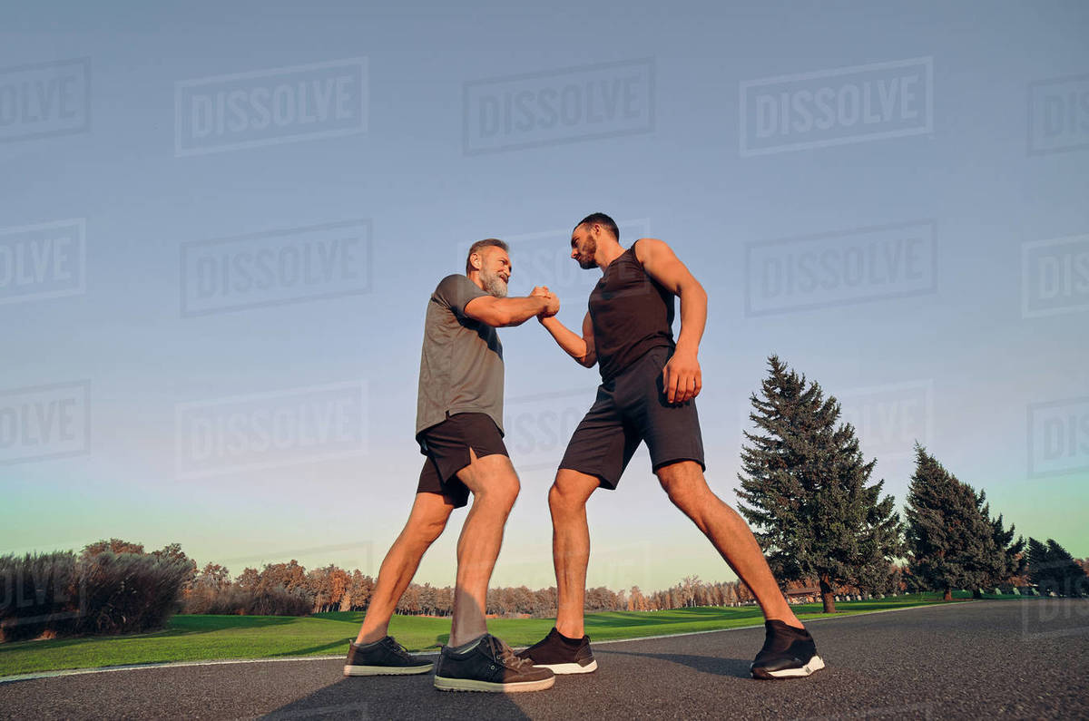The two opponents holding hands in the park - Stock Photo - Dissolve
