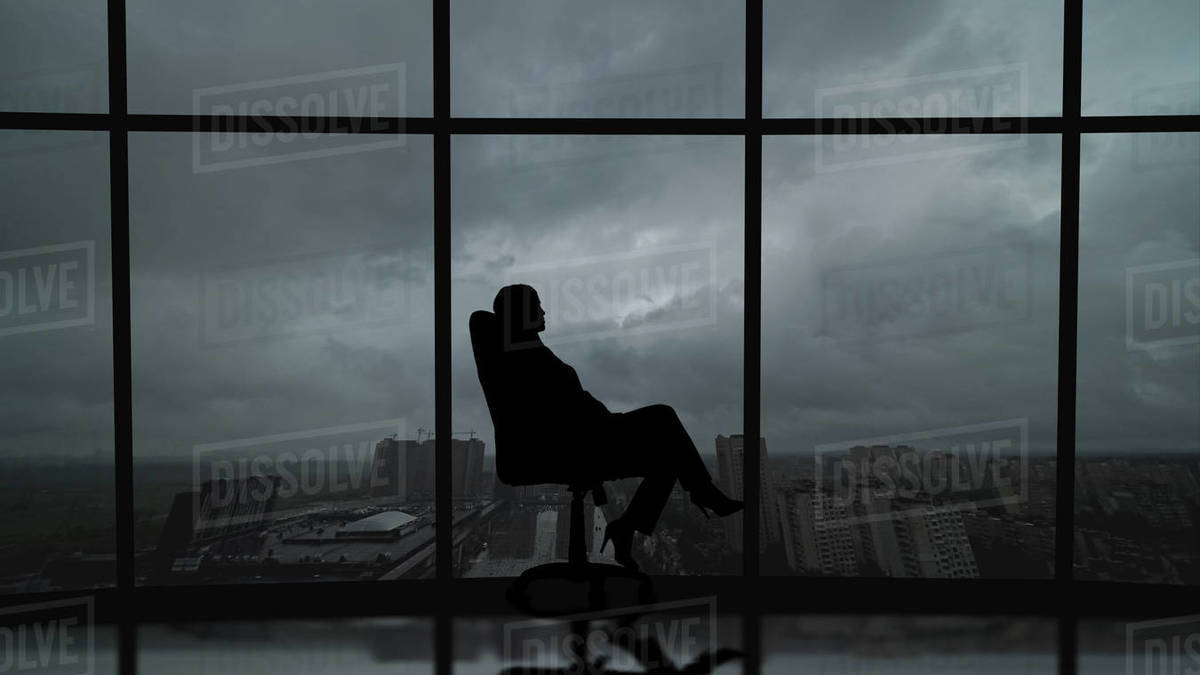 The business woman sits in the office near the windows with a beautiful ...