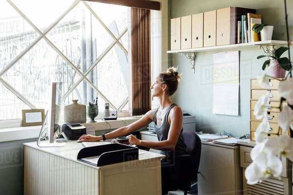 Woman in office using computer - Royalty-free Stock Photo | Dissolve