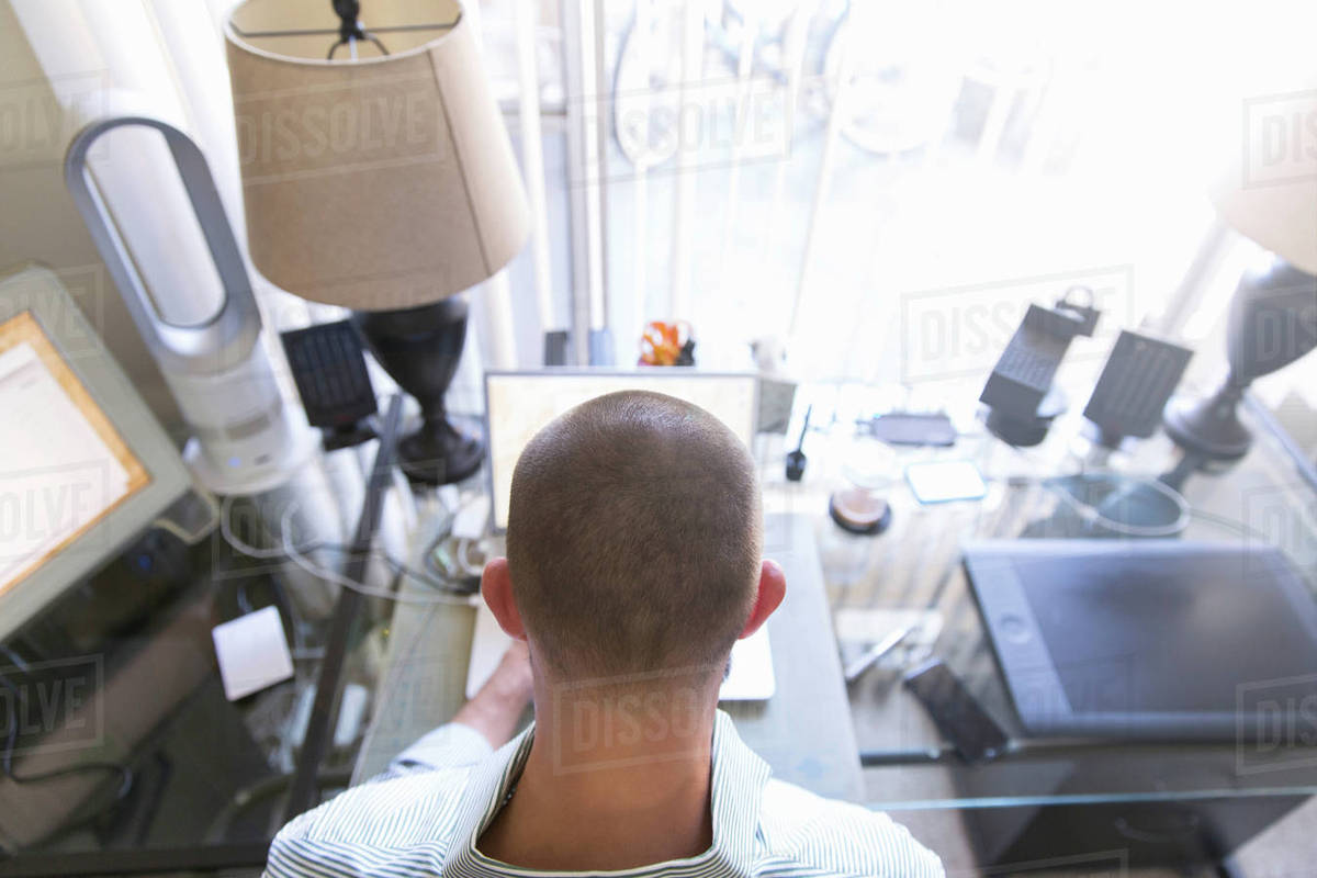 Rear view of man typing on laptop, working at home - Royalty-free Stock ...