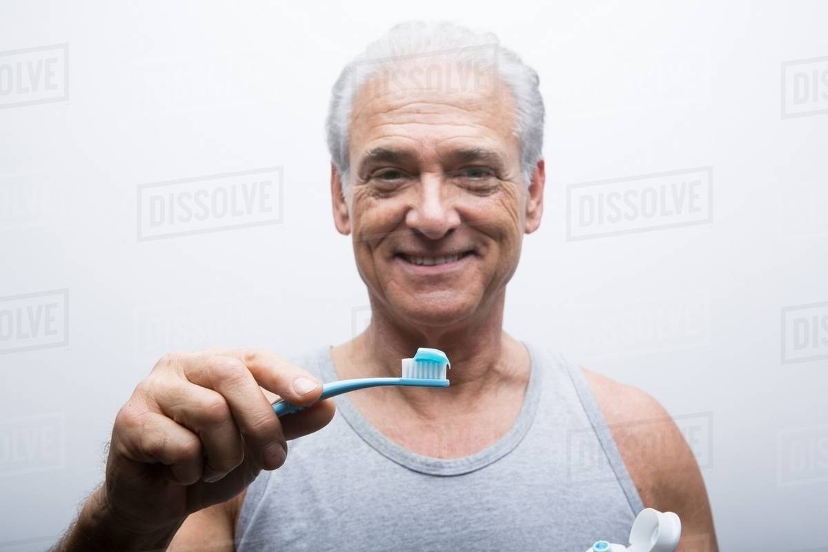 Senior man holding toothbrush, portrait - Royalty-free Stock Photo ...