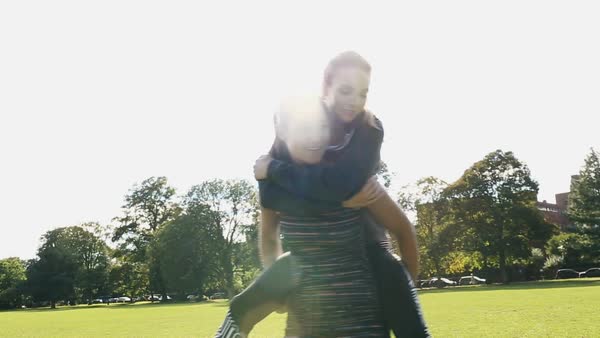 Woman carrying another woman on her back in park - Stock Video Footage ...