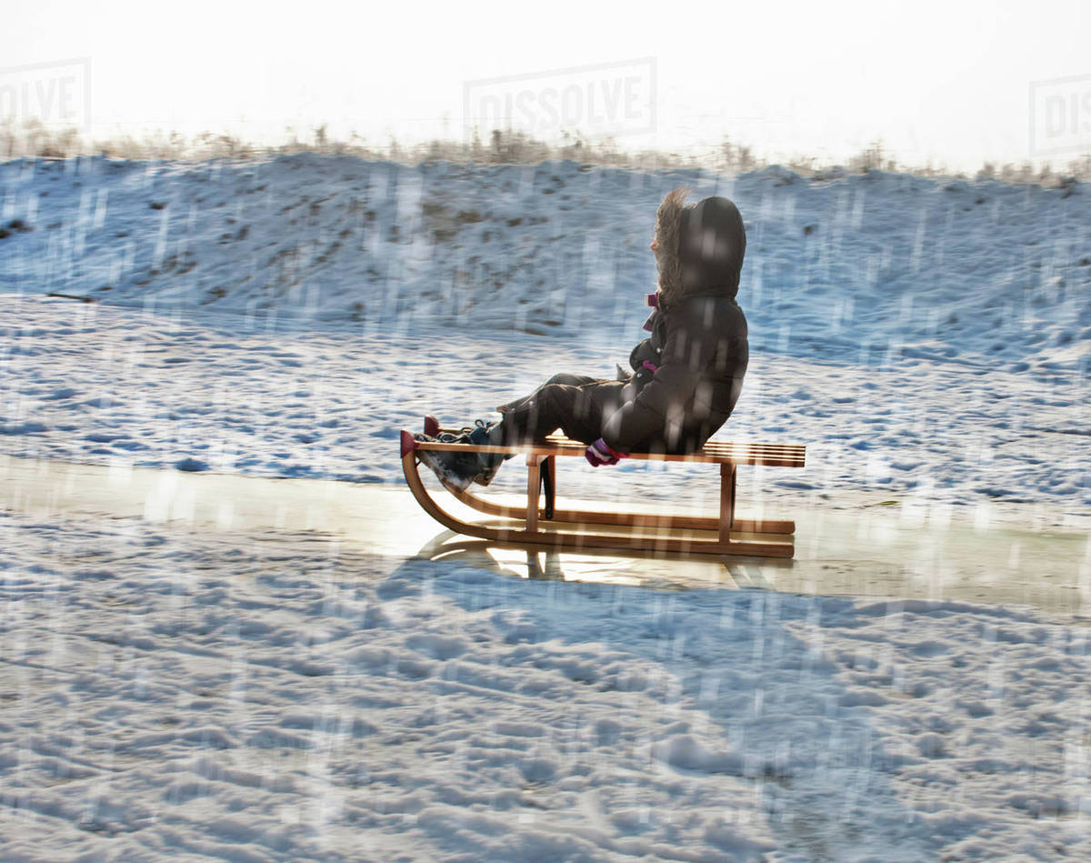 Boy sledding in snow - Royalty-free Stock Photo | Dissolve