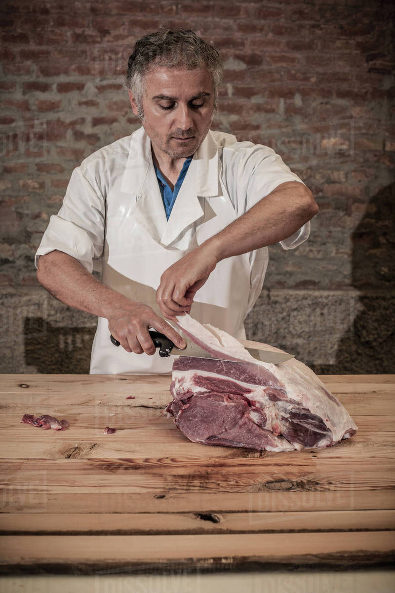 Butcher carving meat in shop - Stock Photo - Dissolve